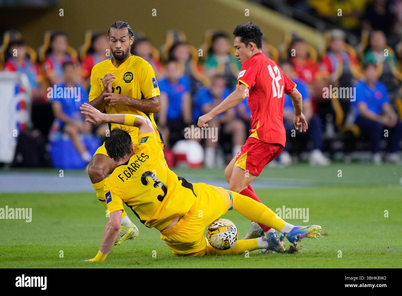 Vietnam's Nguyen Hai Long, right, fight for control of the ball with Malaysia's Facundo Tomas ...