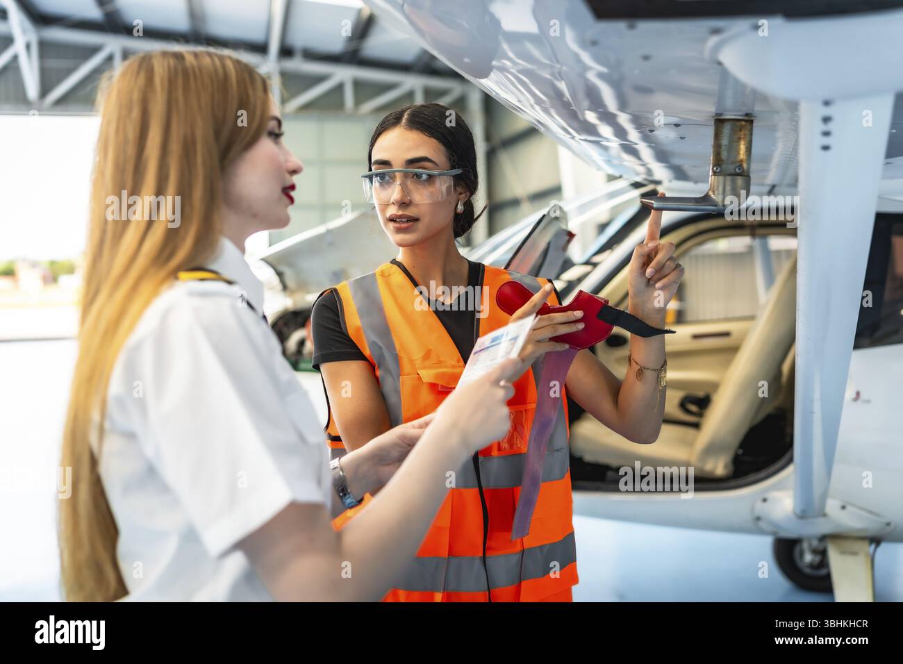 Female aircraft maintenance engineer wearing high visibility vest ...