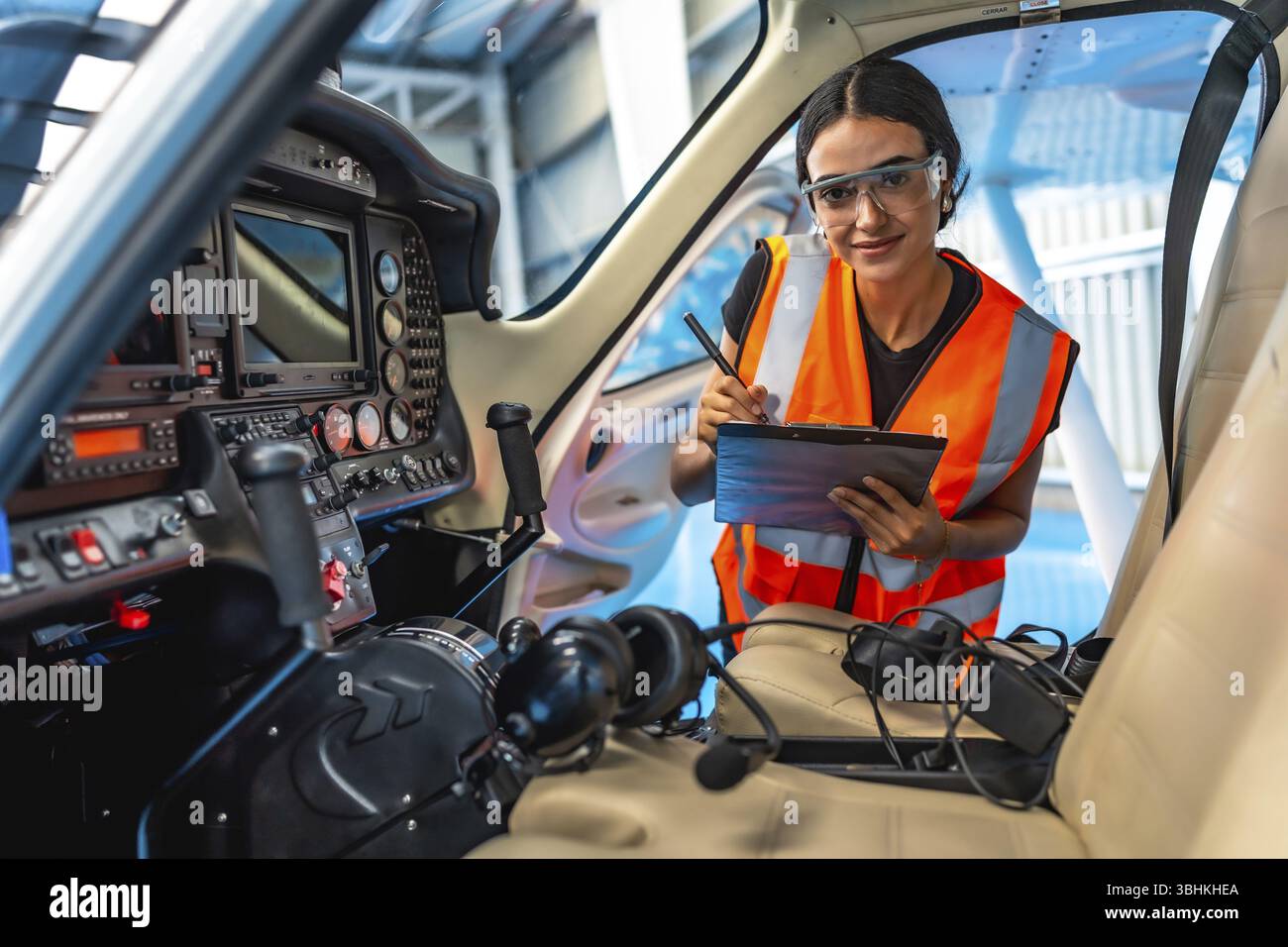 Female aircraft maintenance engineer taking notes while inspecting the ...