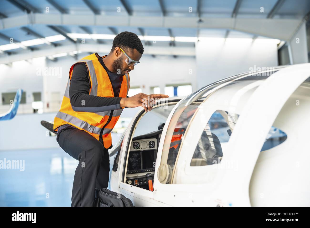 Aircraft maintenance engineer wearing safety glasses and a high ...