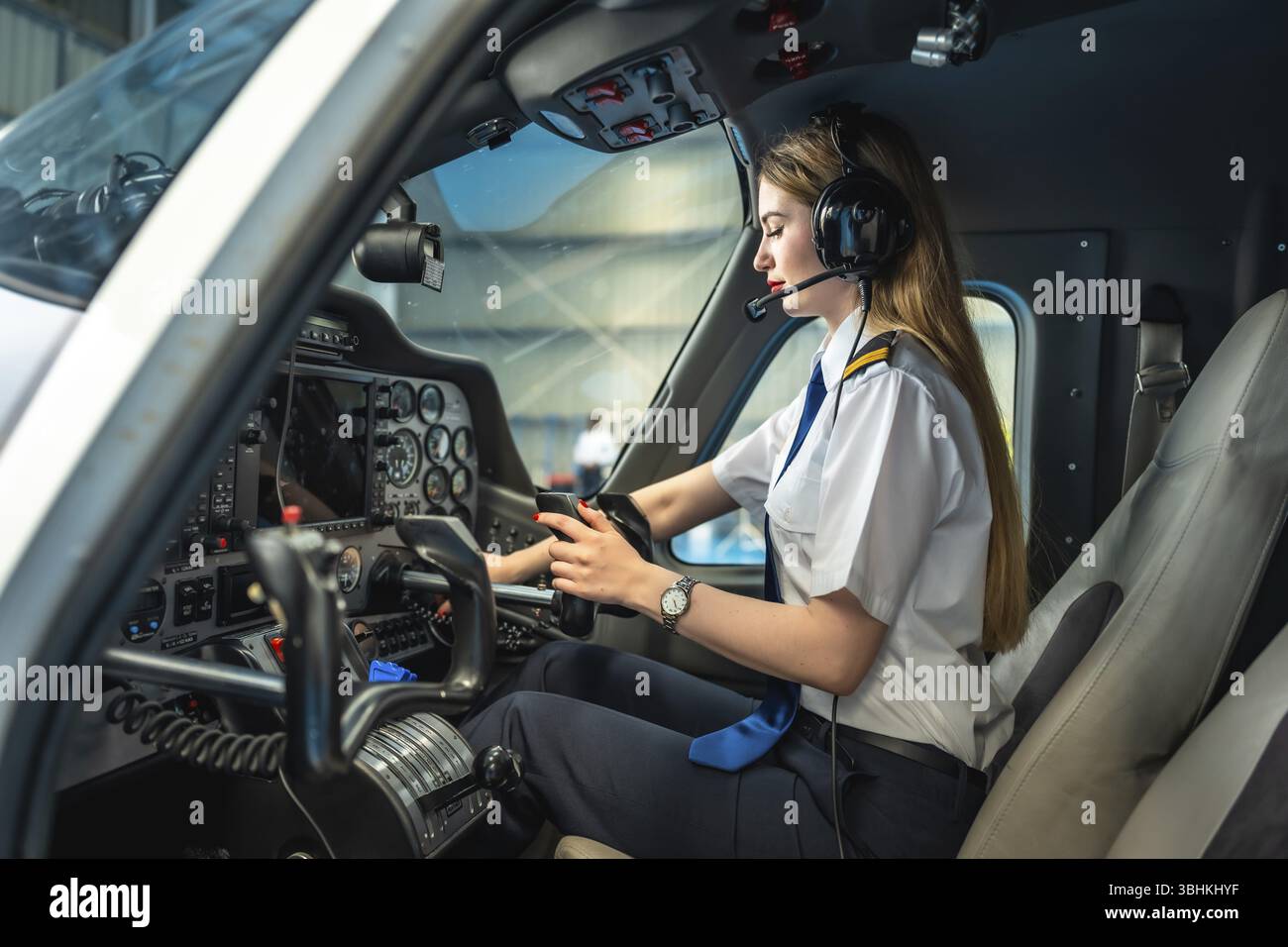 Confident female pilot using electronic flight bag while sitting in ...