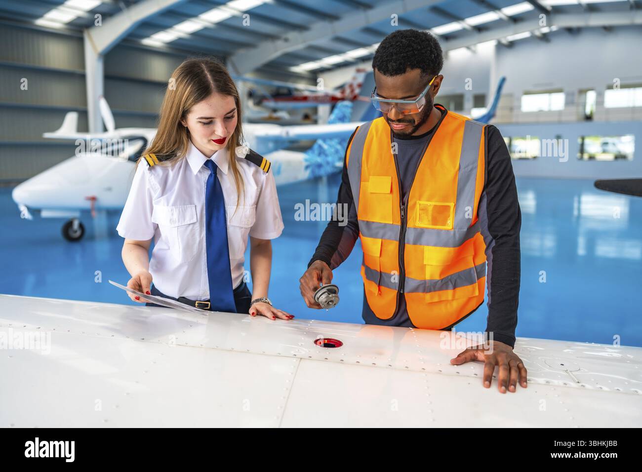 Aircraft maintenance engineer shows a fuel sample to a pilot during a ...