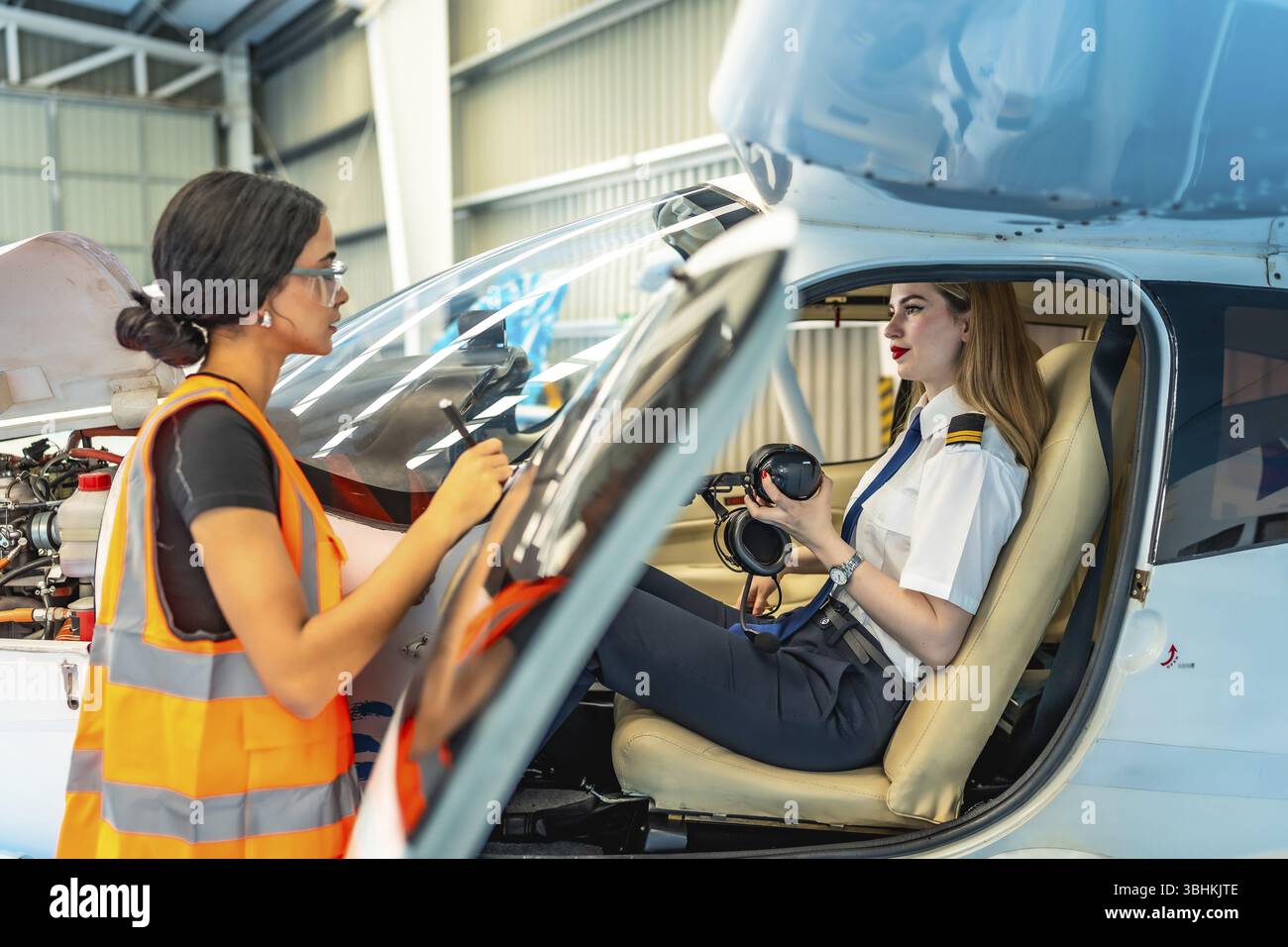 Aircraft maintenance supervisor taking notes while talking to female ...