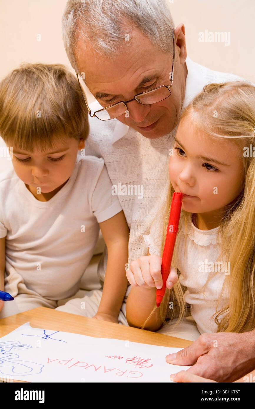 Grandpa is teaching his grandchildren to write Stock Photo - Alamy