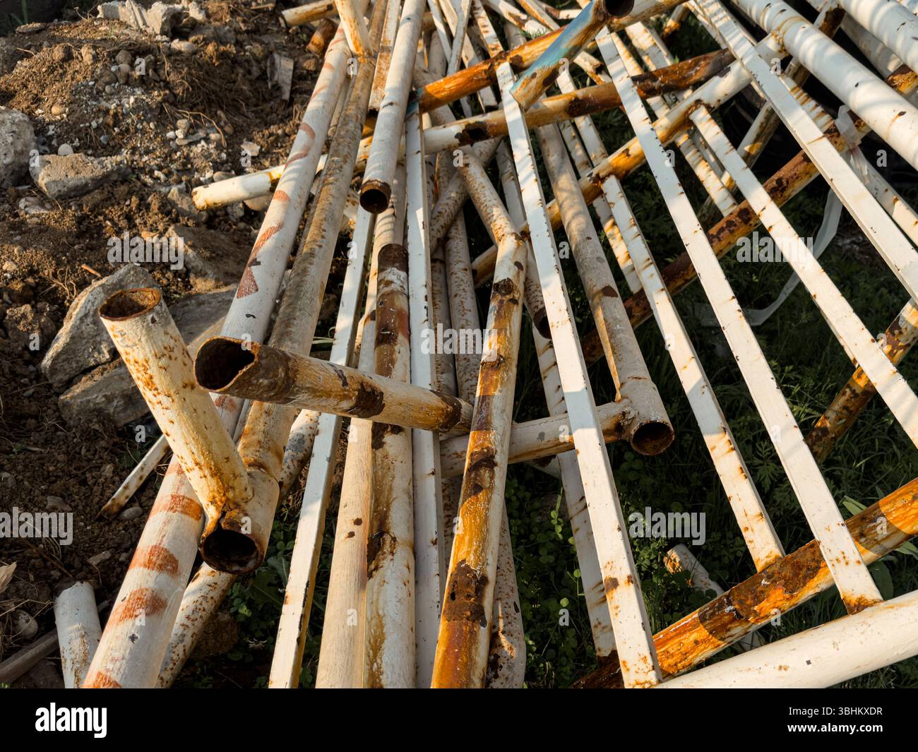 Pile of rusty construction pipes with grid-like structure, photographed ...