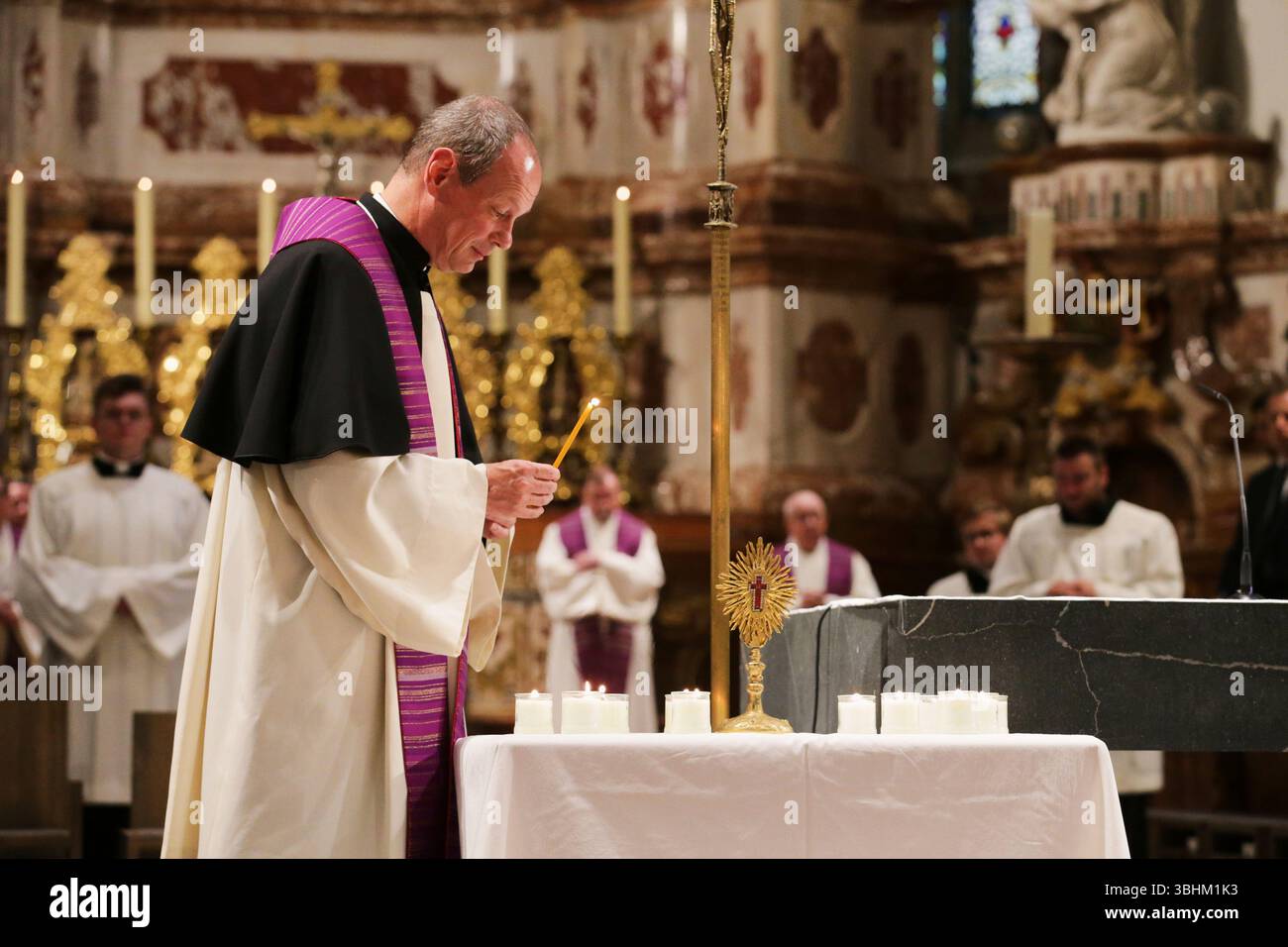 Priest Ewald Pristavec lights candles for the victims of a shooting at ...