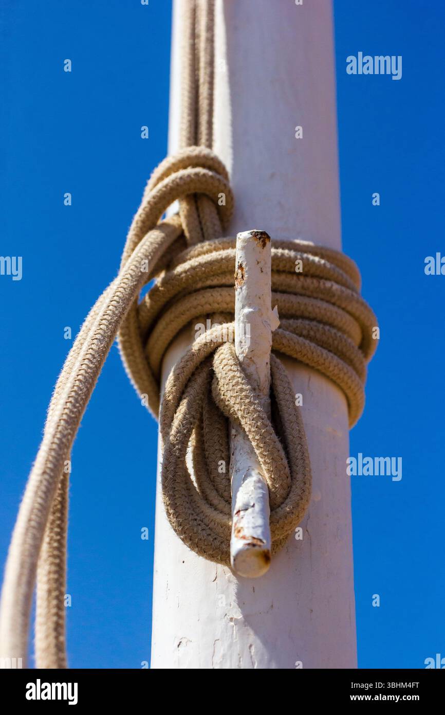 Close-Up of Nautical Rope Coiled Around a Boat Mast Against Blue Sky ...