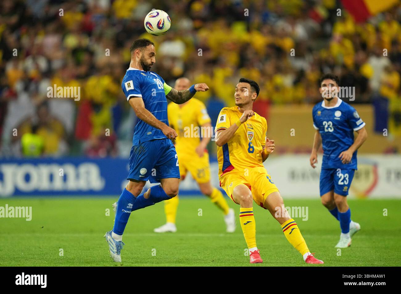 Cyprus' Grigoris Kastanos heads the ball next to Romania's Adrian Sut ...