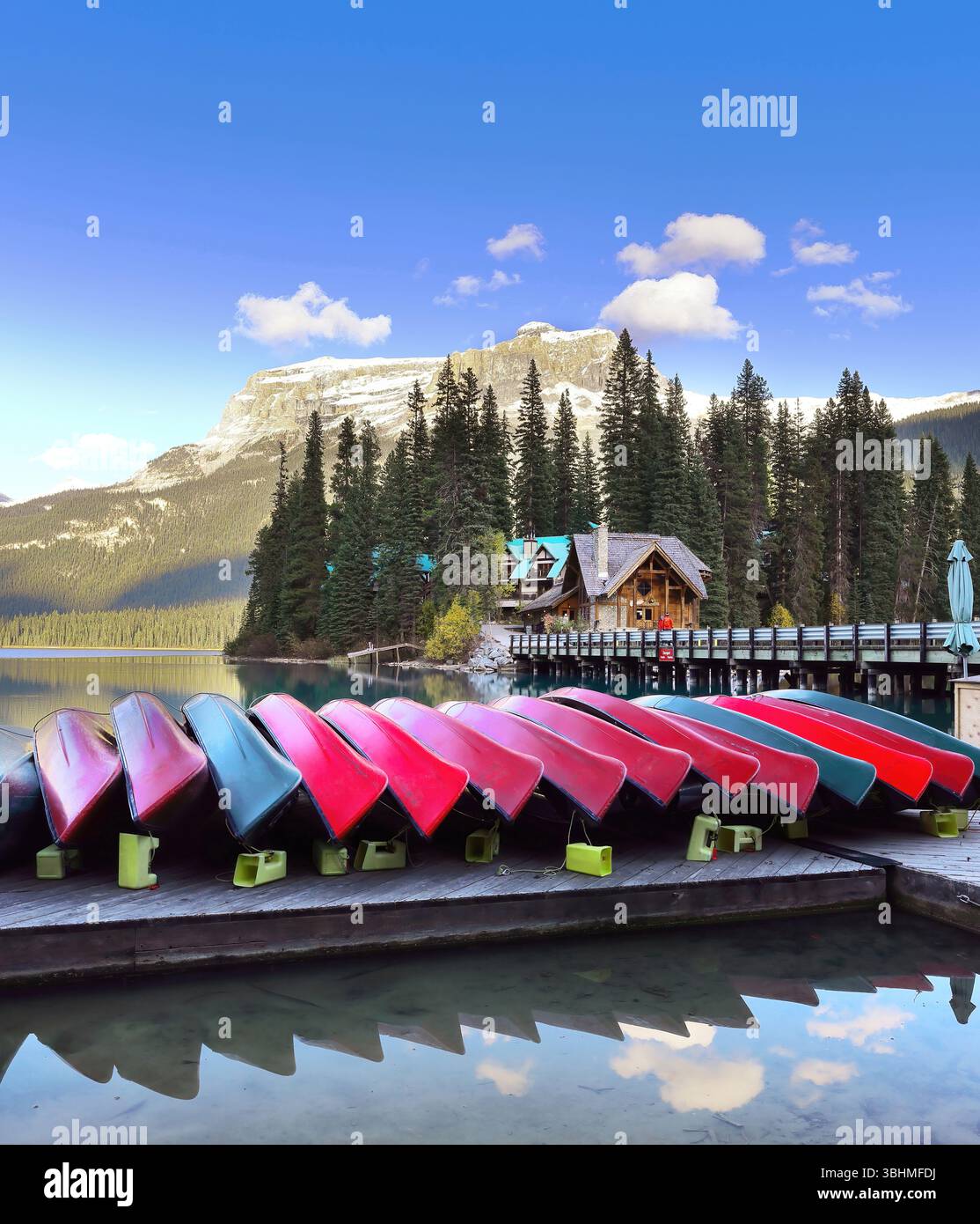 353 Tourist canoes docked upon a wood berth on Emerald Lake SW bank, Lodge Peninsula buildings ...