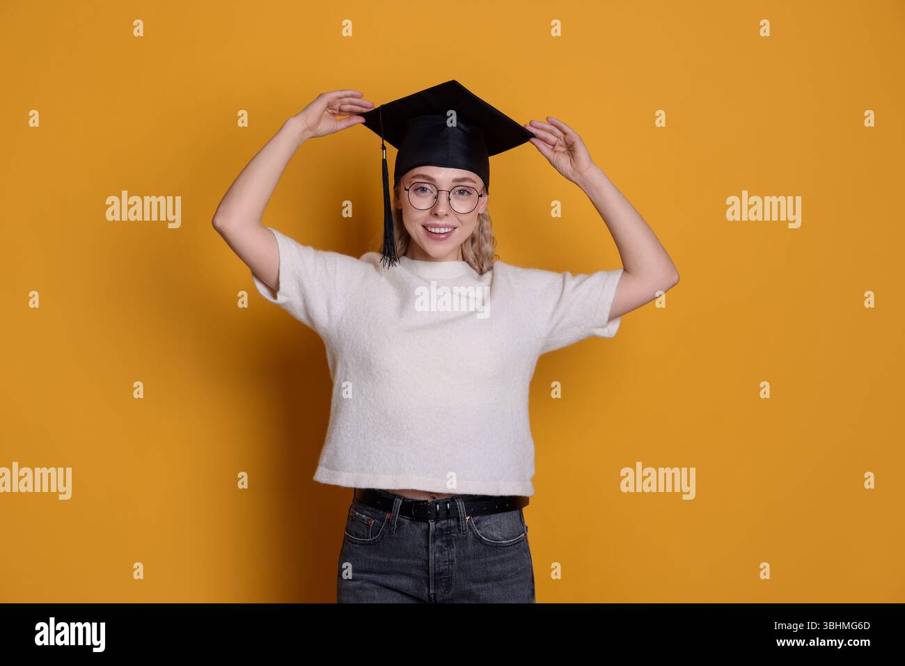 Happy student after graduation on orange background Stock Photo - Alamy