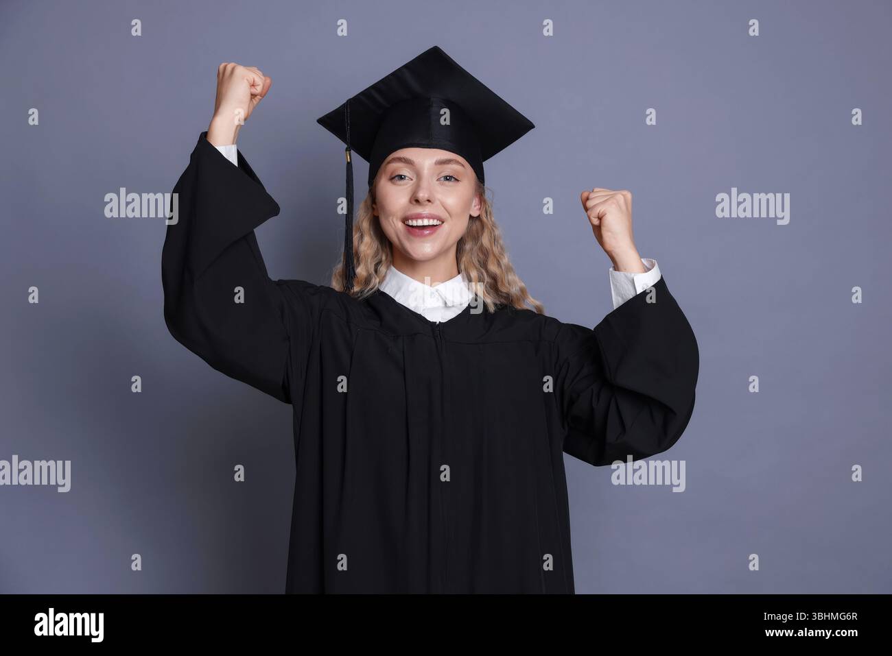 Happy student after graduation on grey background Stock Photo - Alamy