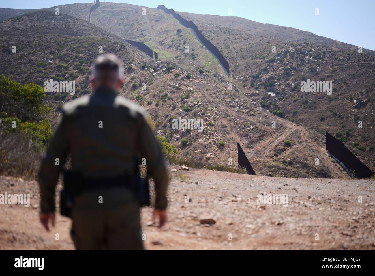 Border Patrol Agent Rood looks out to a gap in the two border walls ...