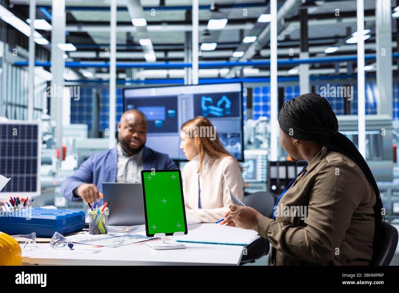 Solar panels plant executives team using mockup device to track energy ...