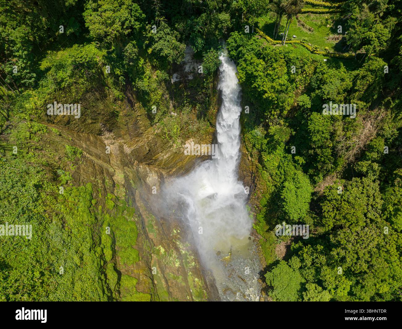 Mist from water splash of Hikong Bente Waterfall surrounded by mountain ...