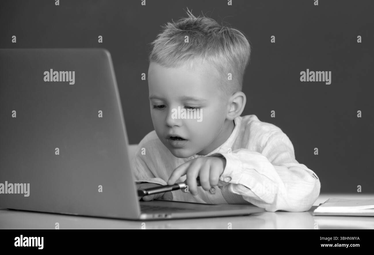 School child using digital pc laptop in class. Portrait of funny pupil of primary school study ...