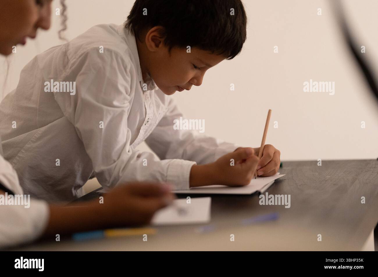 Elementary school student drawing on notebook with pencil Stock Photo ...
