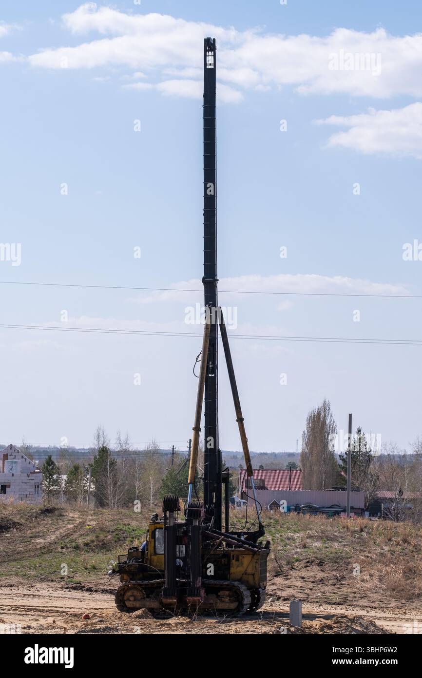 Machine for driving piles in ground in field Stock Photo - Alamy