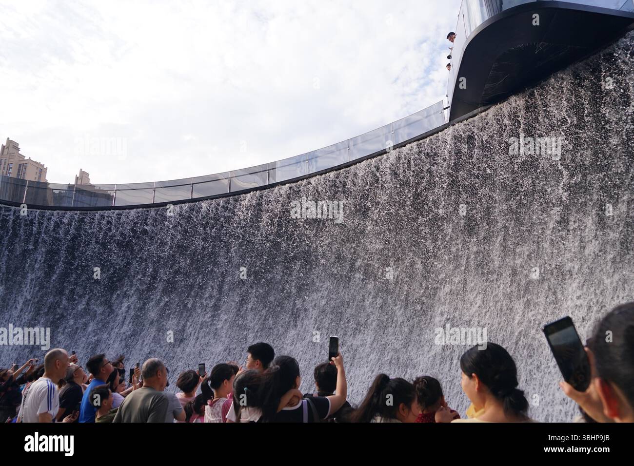 Tourists watch an artificial waterfall in Xi'an City, northwest China's ...