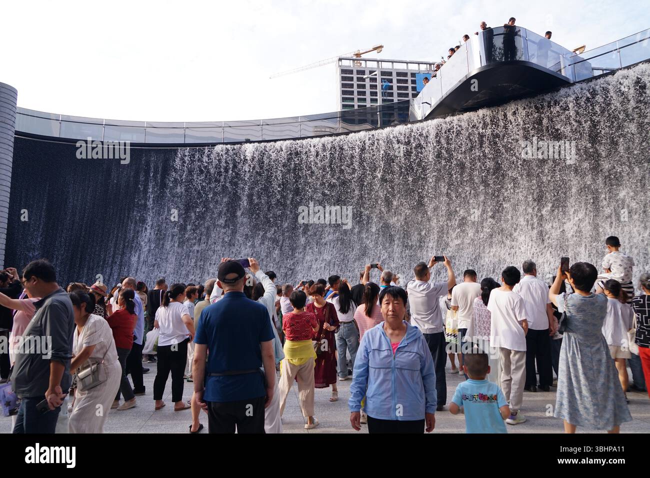 Tourists watch an artificial waterfall in Xi'an City, northwest China's ...