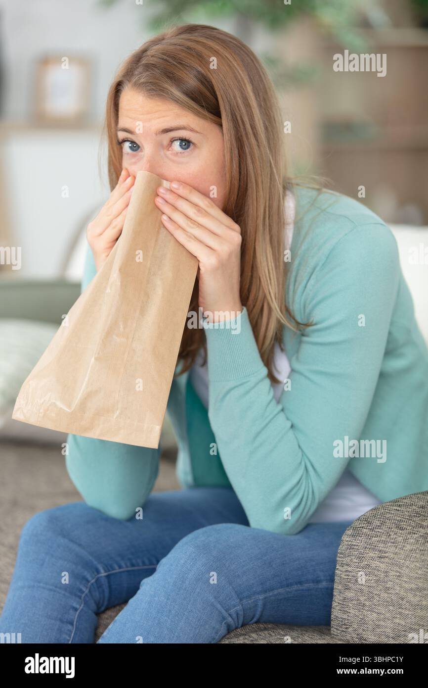 young woman breathing into paper bag Stock Photo - Alamy