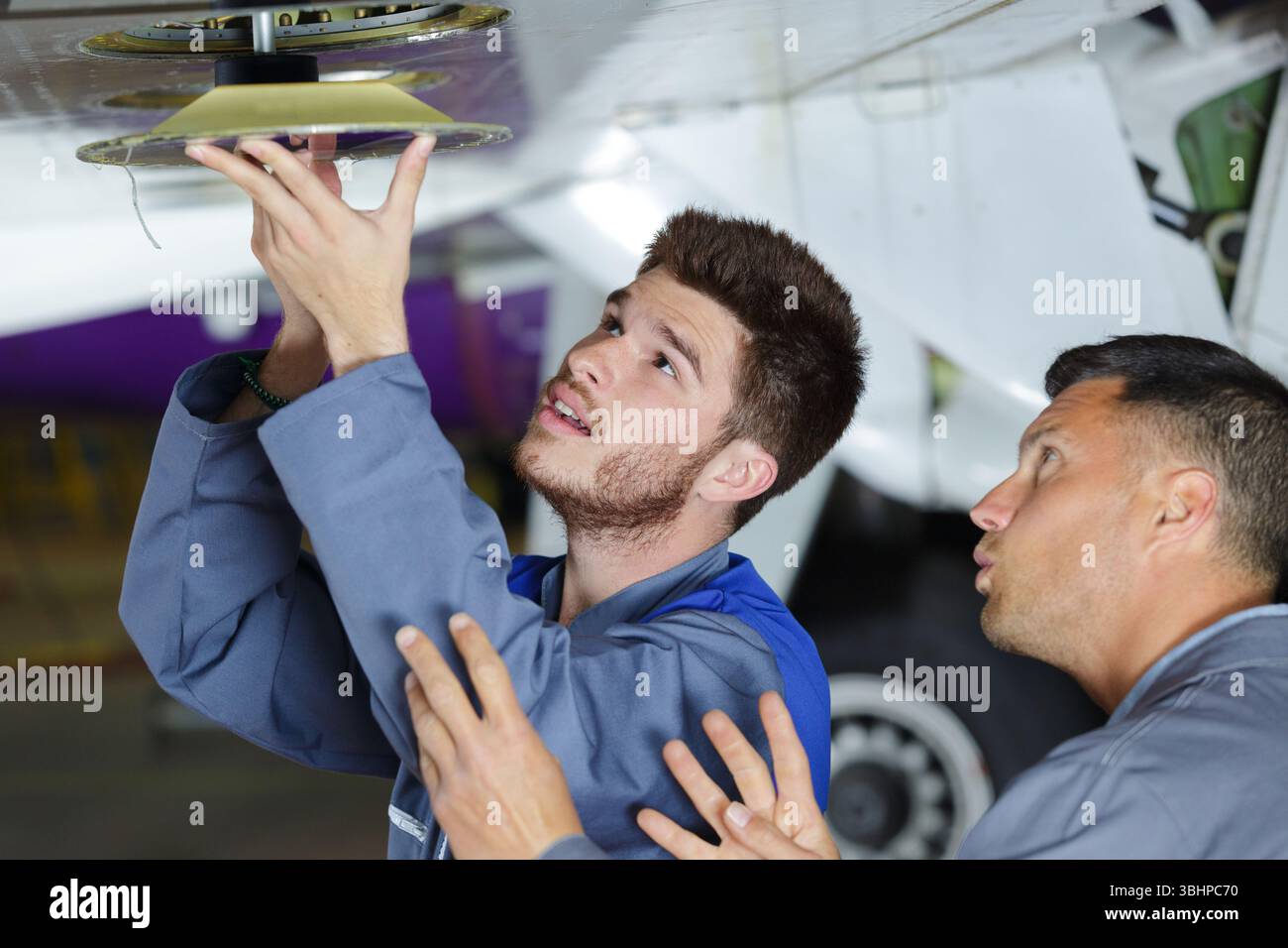 engineers under jet engine in hangar Stock Photo - Alamy