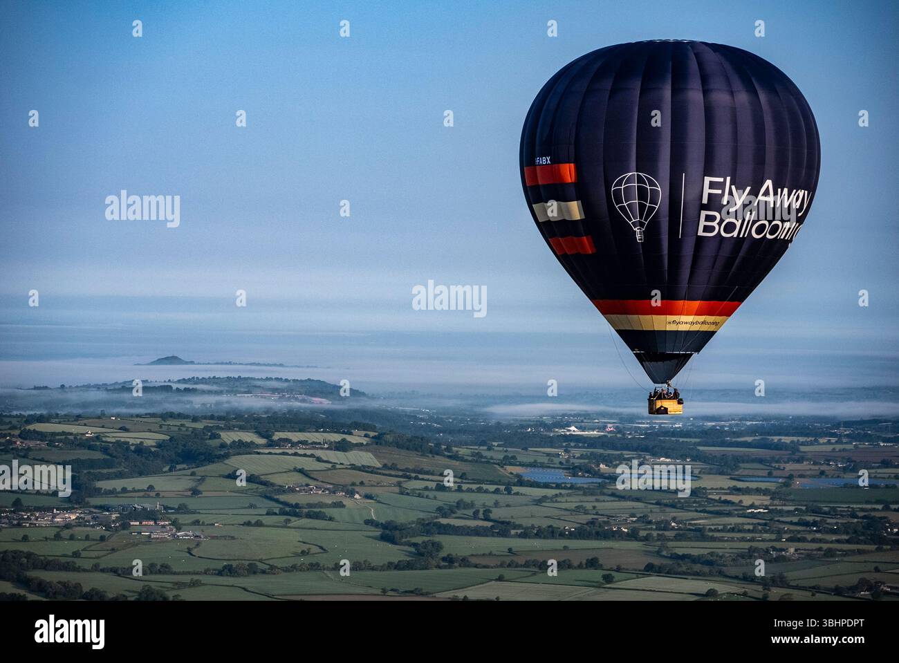 A hot air balloon flies as the sun rises over Gilcombe Farm in Bruton ...