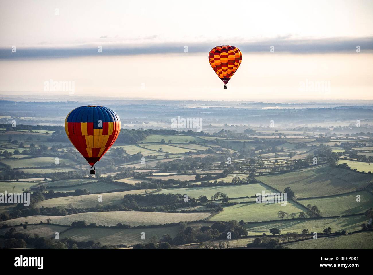 Two of five hot air balloons are launched as the sun rises over ...