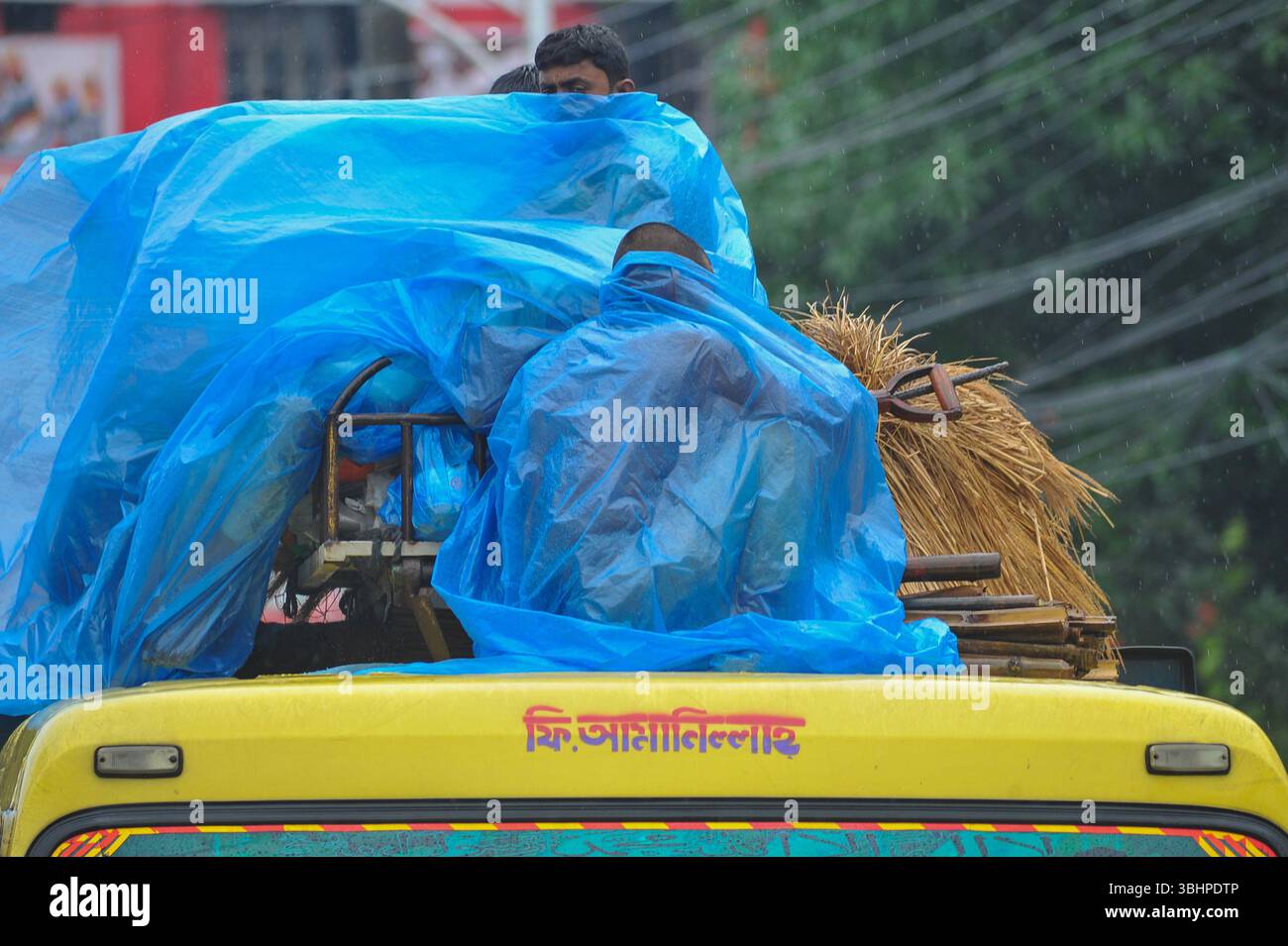 People covered with plastic sheets on trucks during the rain. June ...