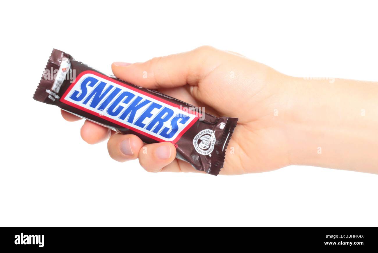 Hand holding Package of the Snickers - Chocolate Bar of Mars ...