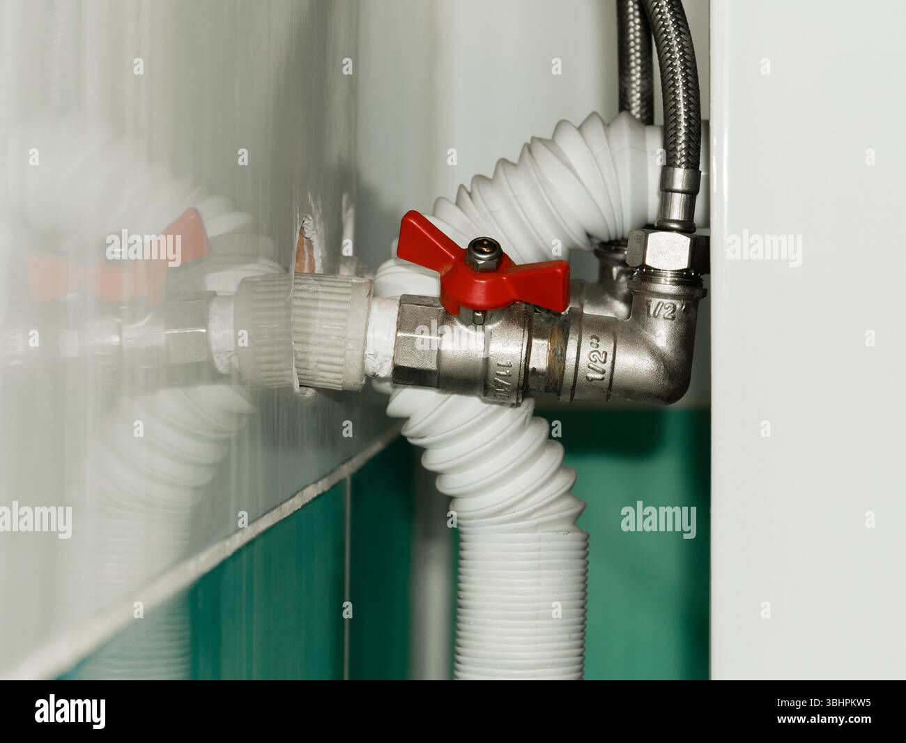 Close-up of a half-inch water ball valve with flexible hoses and ...