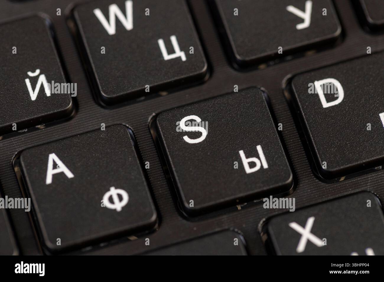 black computer keyboard with English and Russian letters close up, the ...