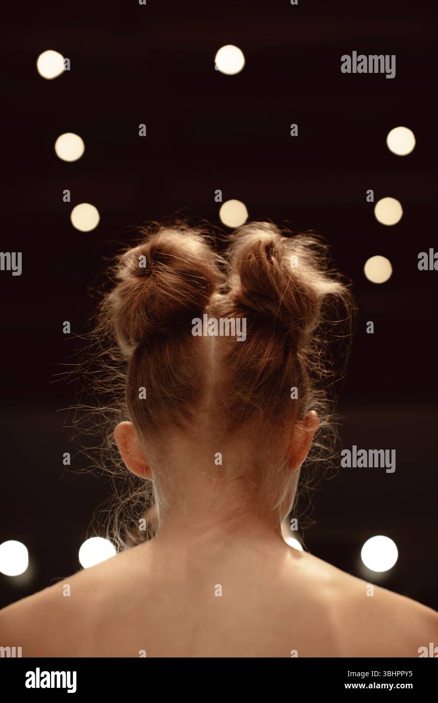 Hairstyle two buns of a young fashion model brunette, hairdo process ...