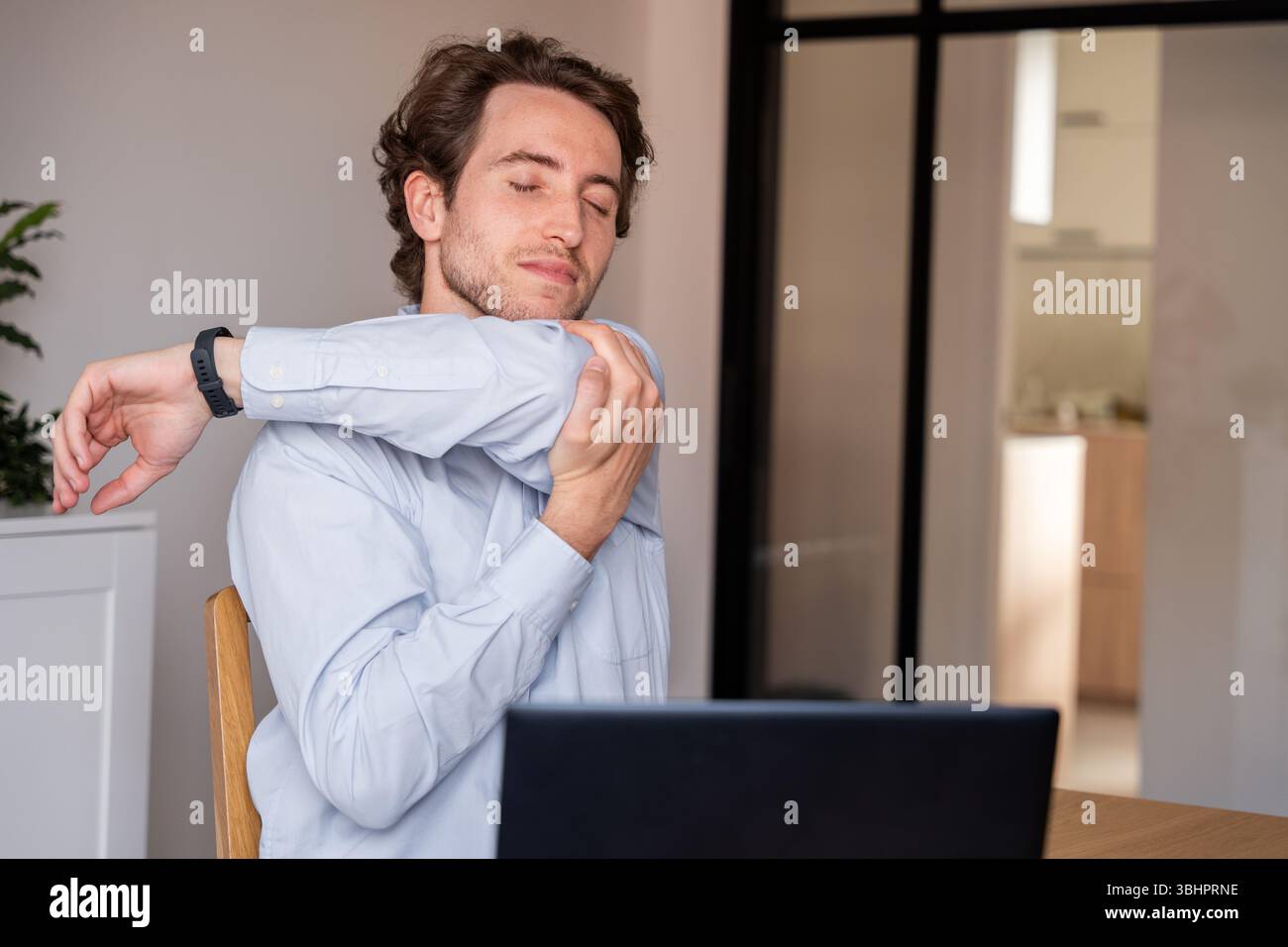 Man stretching arms at the office to relieve tension Stock Photo - Alamy
