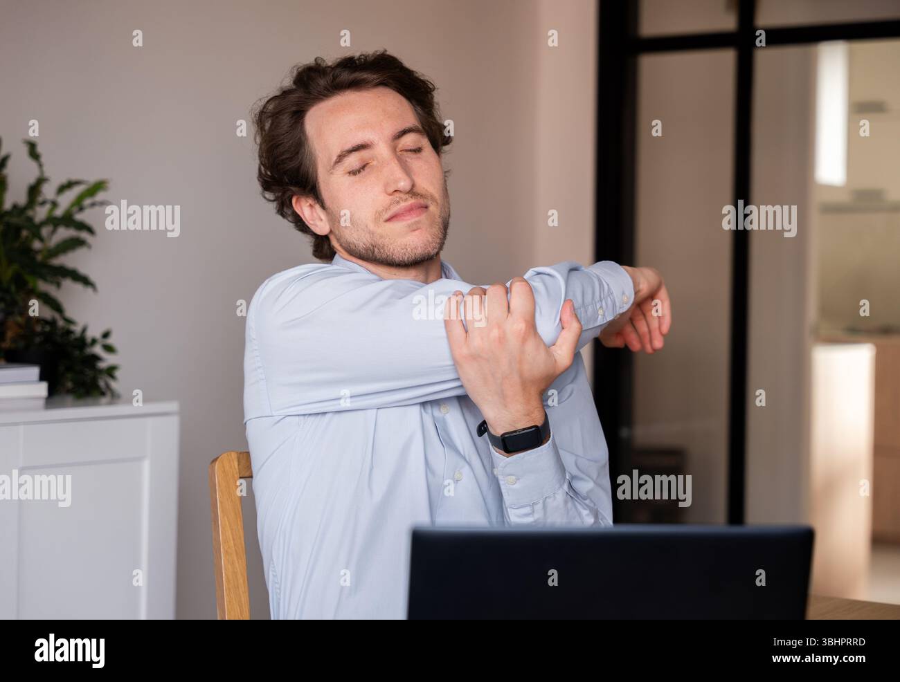 Executive doing stretches to prevent back pain at work Stock Photo - Alamy