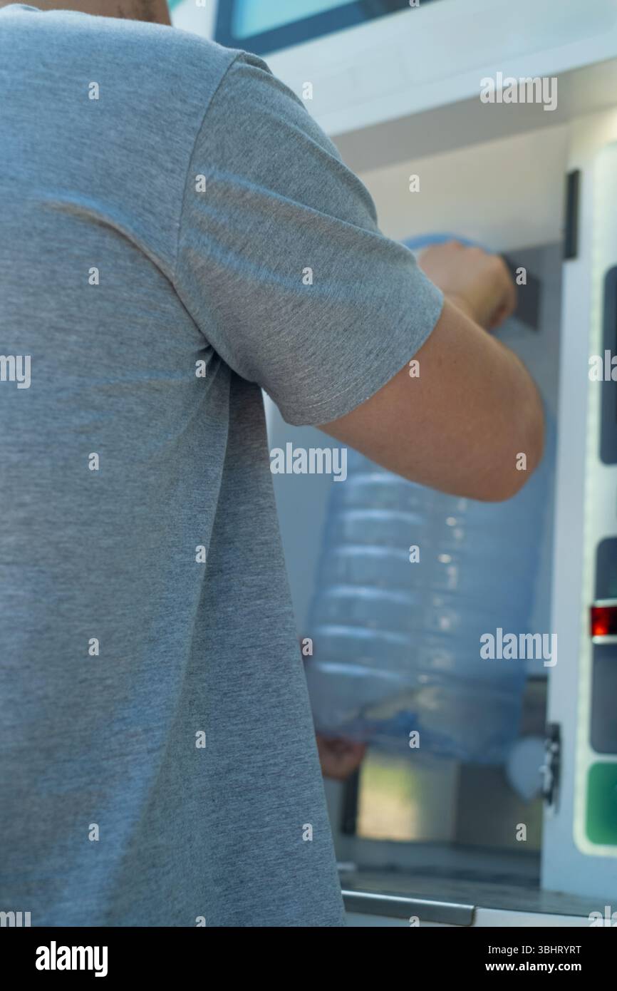 Man at clean water vending machine practicing daily health care routine ...