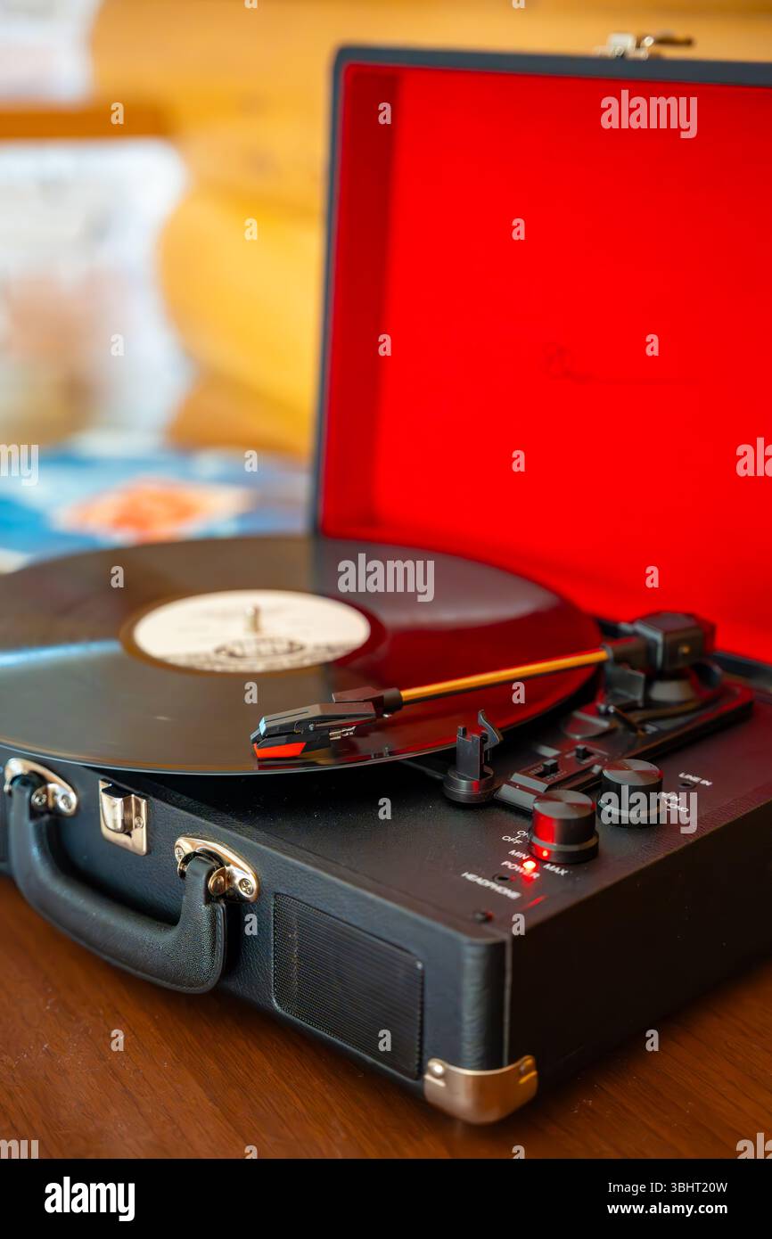 Vintage suitcase-style record player spinning vinyl record. Retro music ...