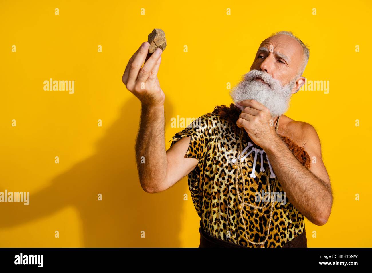 Photo of old man archaeologist in caveman costume look old stone ...