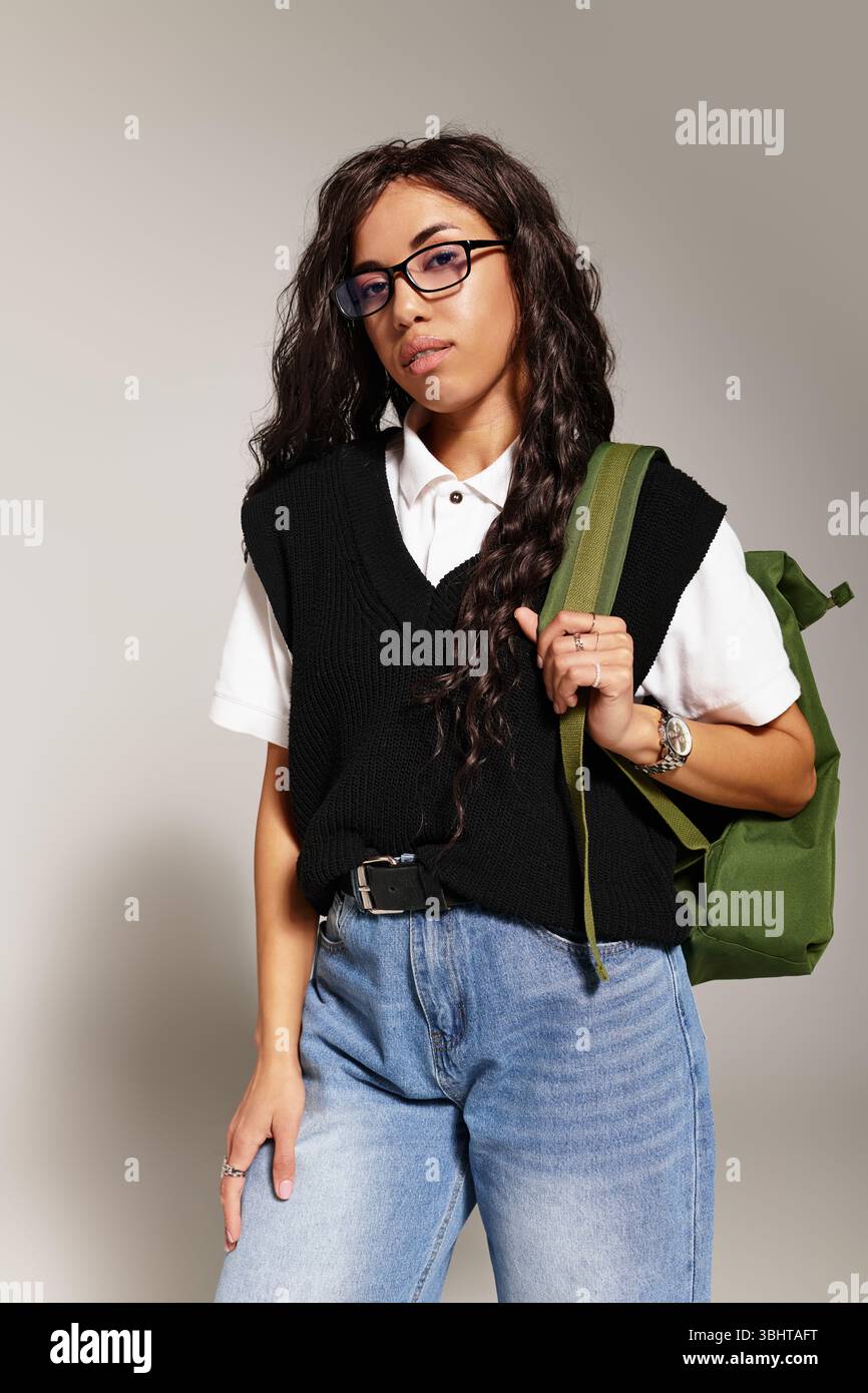 A young student wearing glasses and carrying a backpack poses. She ...