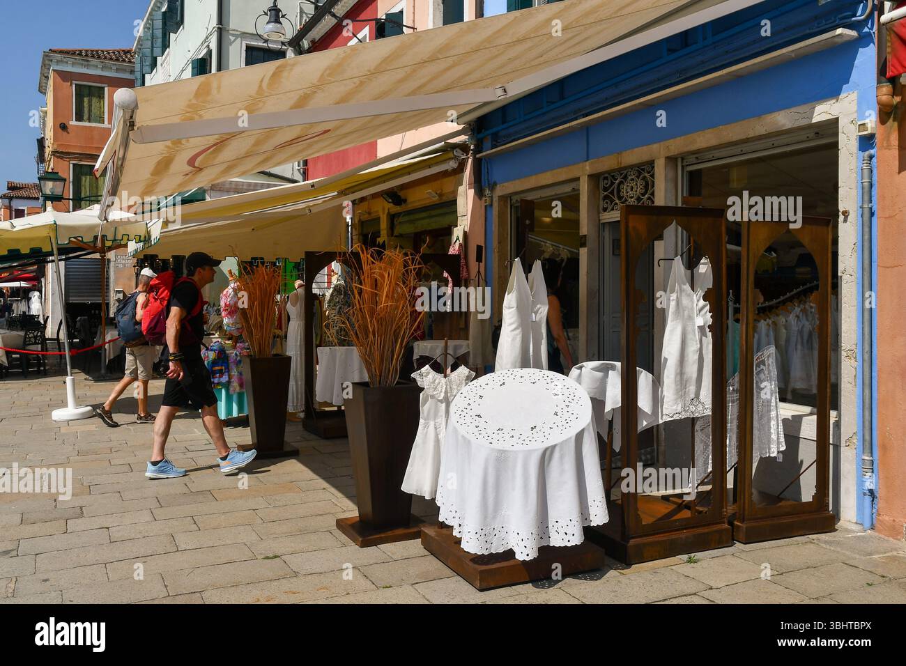 Tourists entering a shop of Burano lace, one of the most renowned lace ...