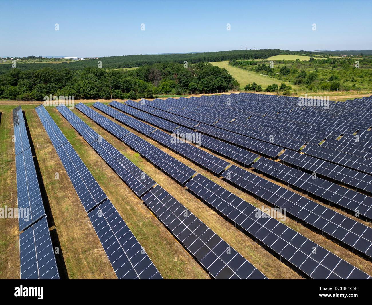 Aerial view of a large solar power plant with rows of photovoltaic ...