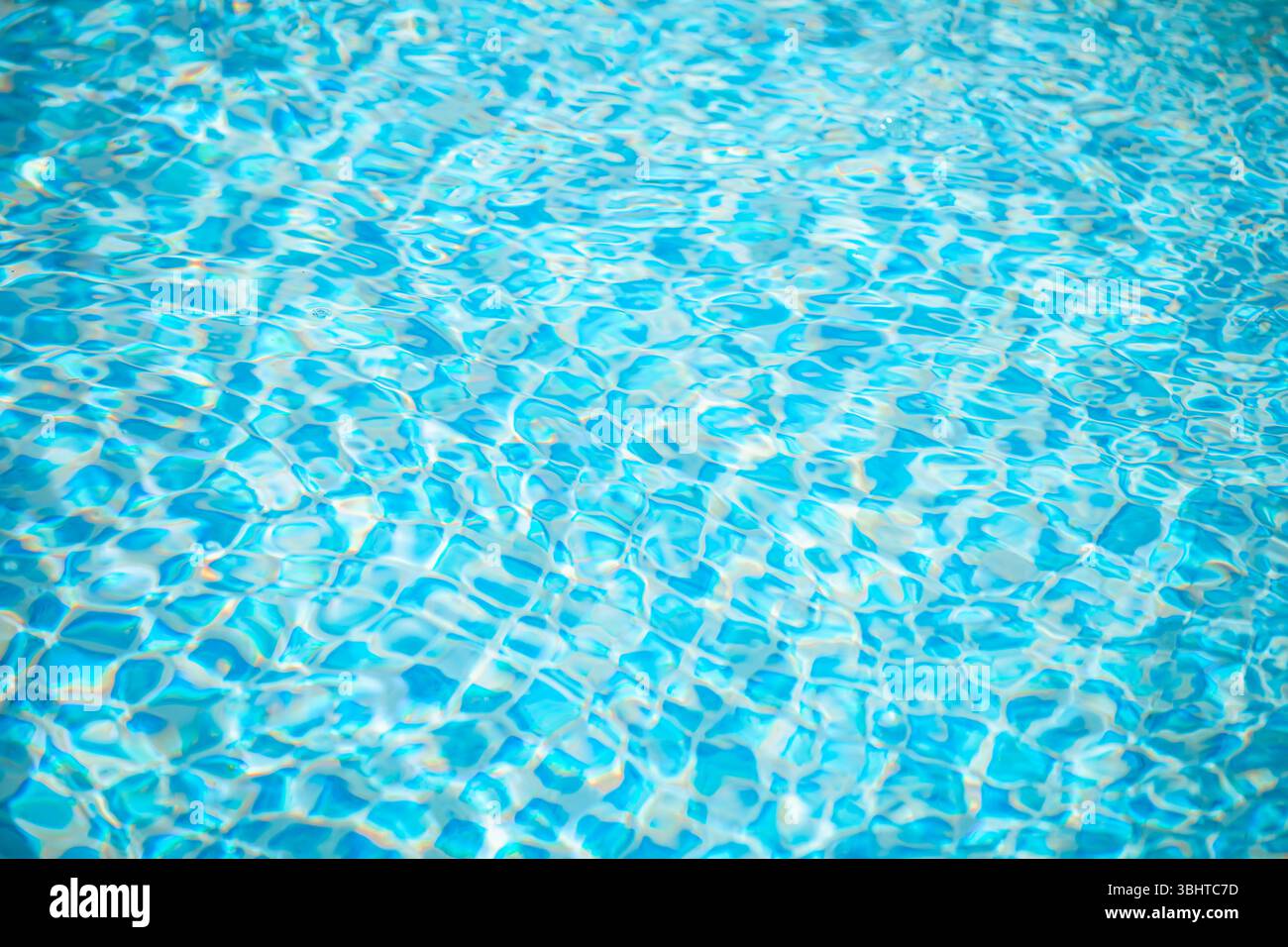 Crystal-clear turquoise blue pool water surface is gently rippling ...