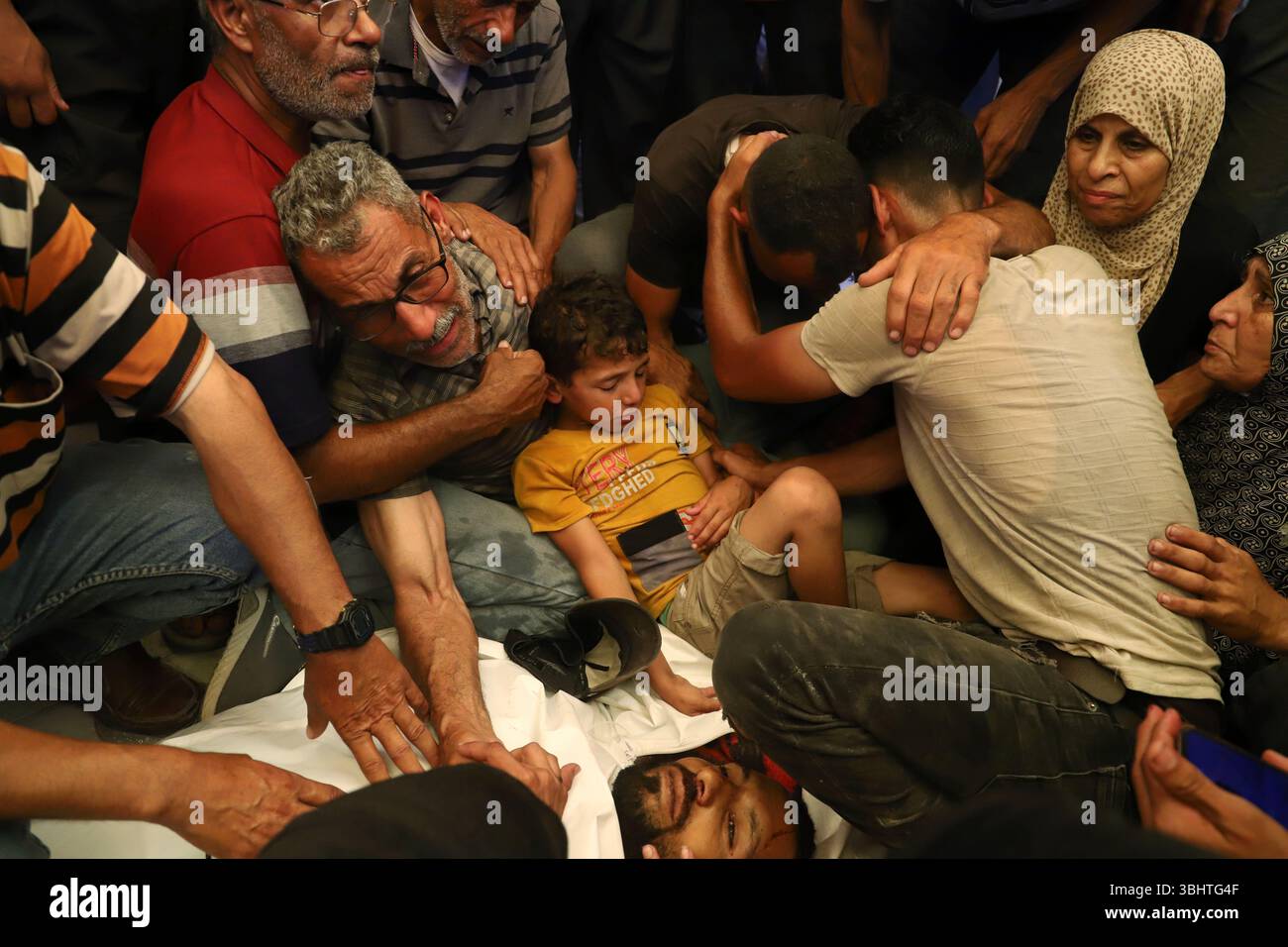 Ata Qasas, center left, mourns over the body of his son Rashad Qasas ...