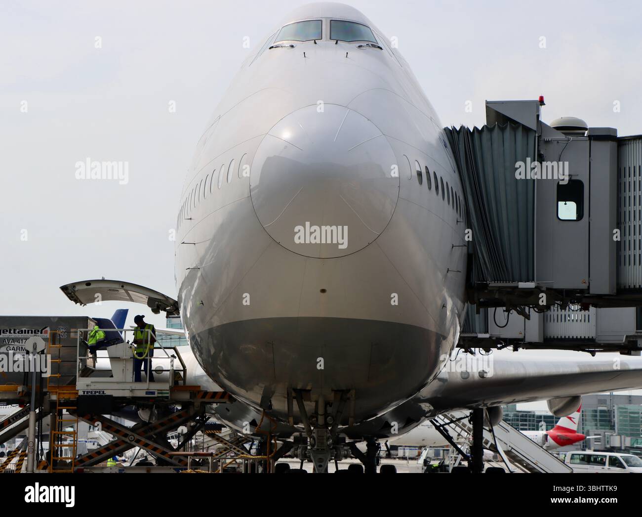 Close up of nose of Lufthansa 747 jumbo jet with luggage being loaded ...