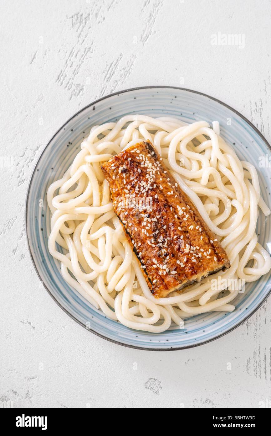 Thick udon noodles topped with glazed eel, richly coated in savory ...
