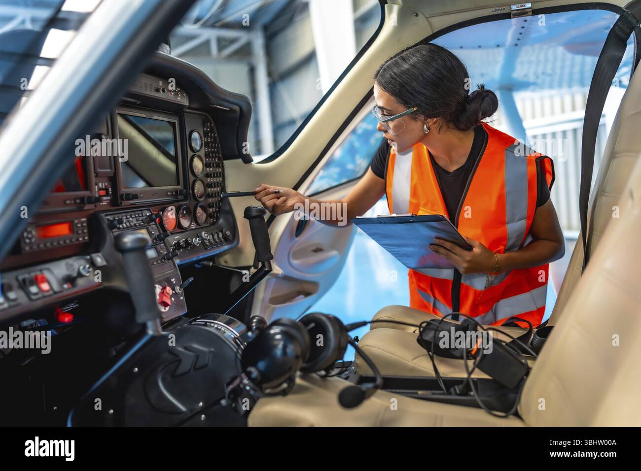 Female aircraft maintenance engineer using checklist while inspecting ...