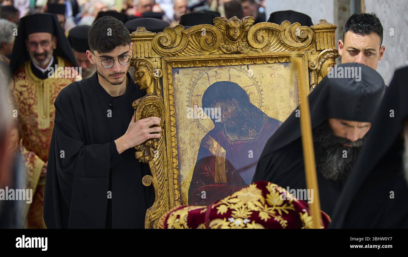 Men in black robes carrying an icon in a golden frame during a ...