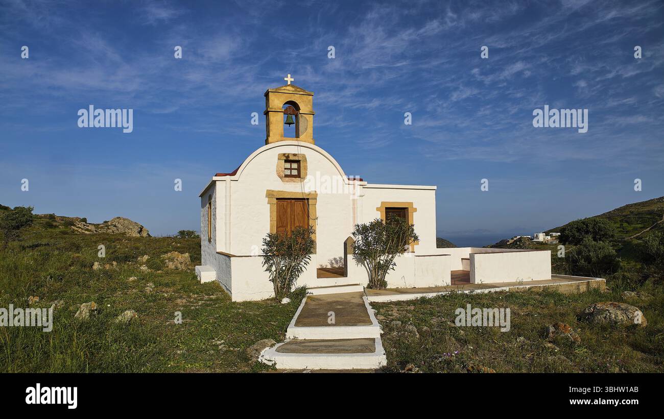 White chapel with bell tower in a rural, Mediterranean setting under a ...