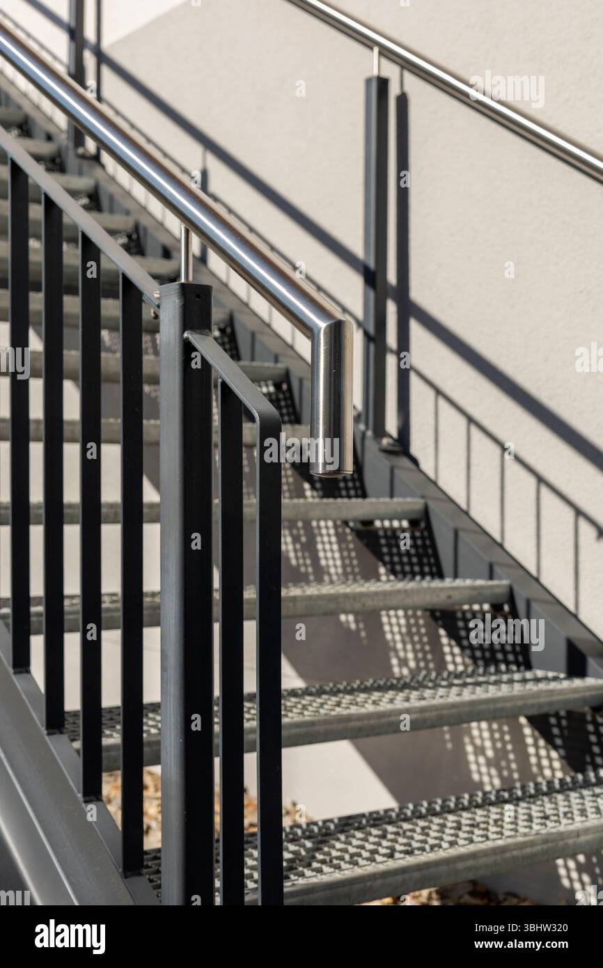 Sleek staircase features metal railings and patterned steps, offering ...