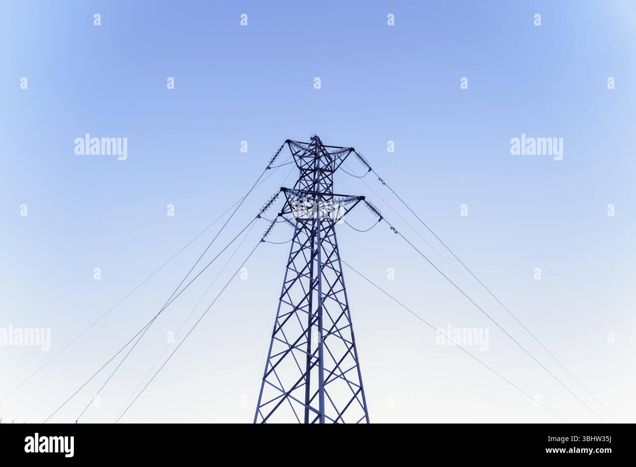 Metal electricity pylon standing tall against a clear blue sky ...