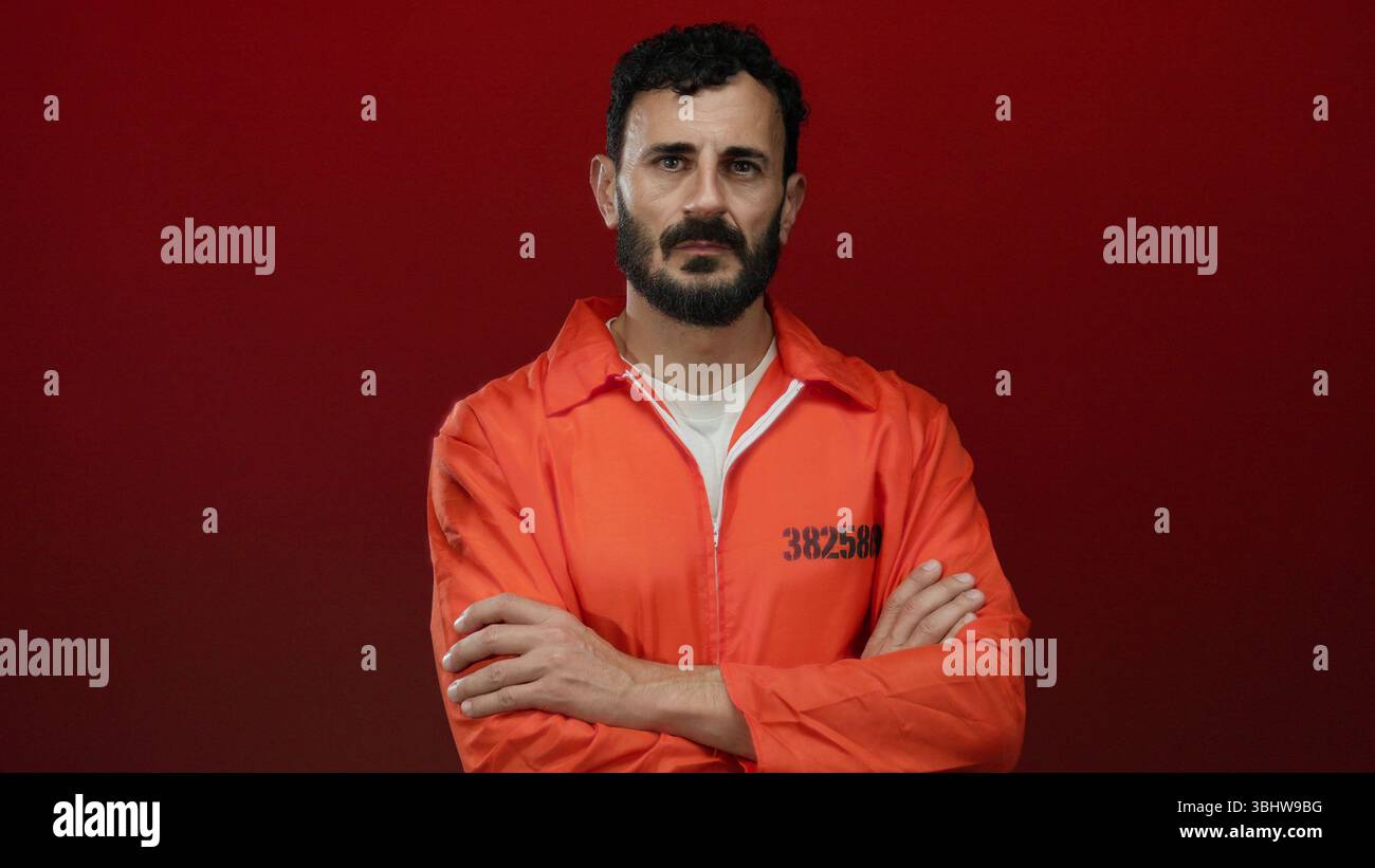 Hispanic man with a beard wearing an orange prison jumpsuit stands ...